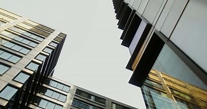 Bottom view of high-rise office buildings with large windows. Sky between glass skyscrapers. in 4k, red komodo