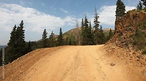 POV while driving a 4WD vehicle along trail cut in mountain side above Poughkeepsie Gulch near Ouray Colorado; concepts of concept of adventure exploration and adrenaline