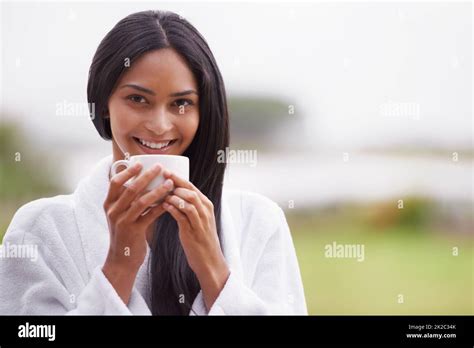 Enjoying Her Morning Cup Of Coffee A Beautiful Young Woman Enjoying A Cup Of Coffee While