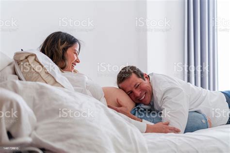 Formally Dressed Couple Are Lying On Their Bed Enjoying The Wifes Pregnant Belly Congratulations