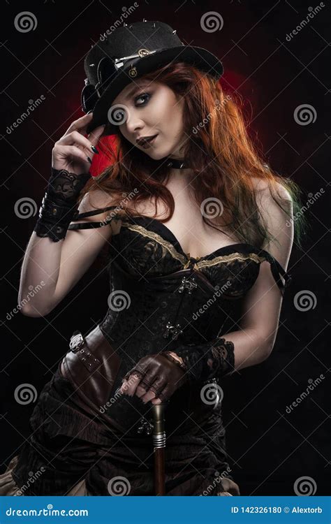 Beautiful Smiling Redhead Cosplayer Girl Wearing A Victorian Style Steampunk Costume And Hat