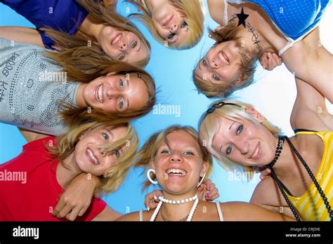 7 Teenage Girls In A Circle Holding Eachother By The Shoulders Putting Their Heads Together And