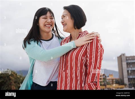 Happy Asian Mother And Daughter Having Fun Hugging Outdoor Focus On Senior Woman Face Stock