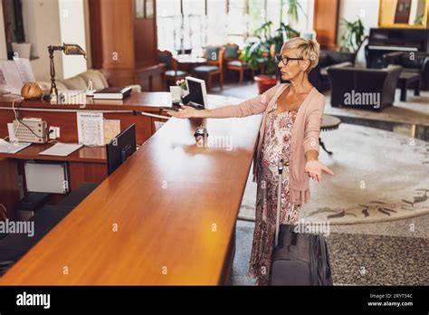 Mature Woman Comes To The Hotel At The Reception She Is Tired Of Waiting For Receptionist Stock