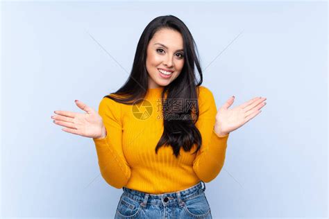 身穿孤立蓝背景的哥伦比亚年轻女孩在会议发言后欢呼高清图片下载 正版图片504431403 摄图网