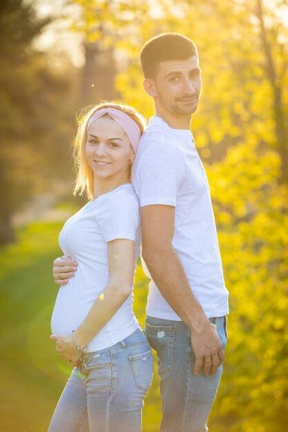 Premium Photo Portrait Of Smiling Man With Pregnant Girlfriend Standing On Land