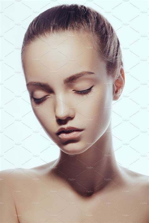 A Woman With Her Eyes Closed Is Looking Down At Something In Front Of Her Face