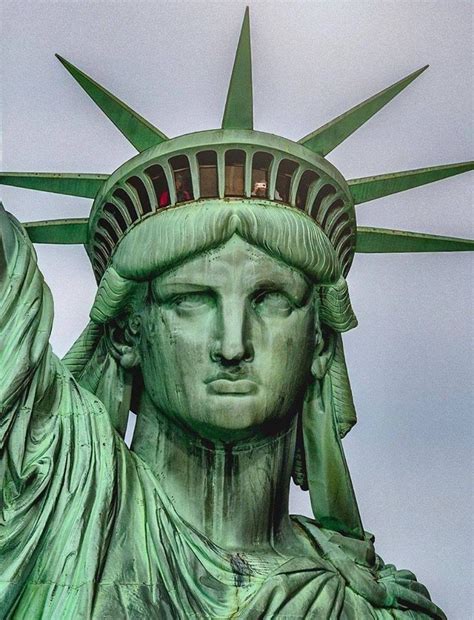 The Statue Of Liberty Has Its Hands Up In Front Of Its Head And Shoulders
