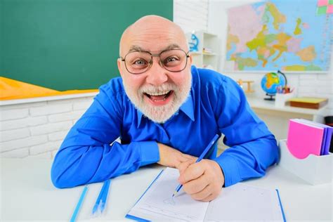 Premium Photo Happy Male Coach Teacher Or University Professor Sitting At Desk In Classroom