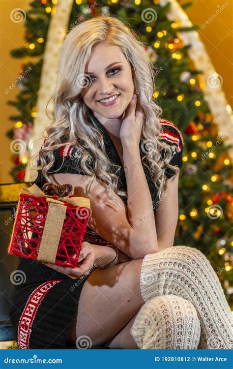 A Lovely Young Blonde Model Enjoys The Holiday Season At Home With A Christmas Tree And Presents