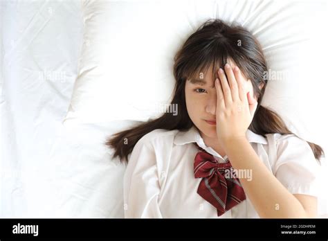 Portrait Japanese School Girl Uniform Sleep And Look At Camera In White Tone Bed Room Stock