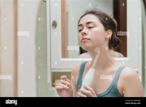A Young Girl Takes Care Of The Skin Of The Face Making Procedures Using The Darsonval Device