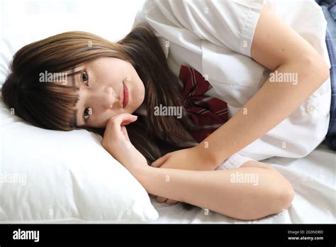Portrait Japanese School Girl Uniform Sleep And Look At Camera In White Tone Bed Room Stock
