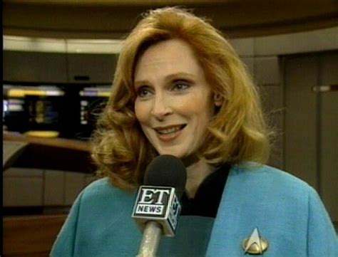 A Close Up Of A Person With A Microphone In Front Of A Tv Screen And Building