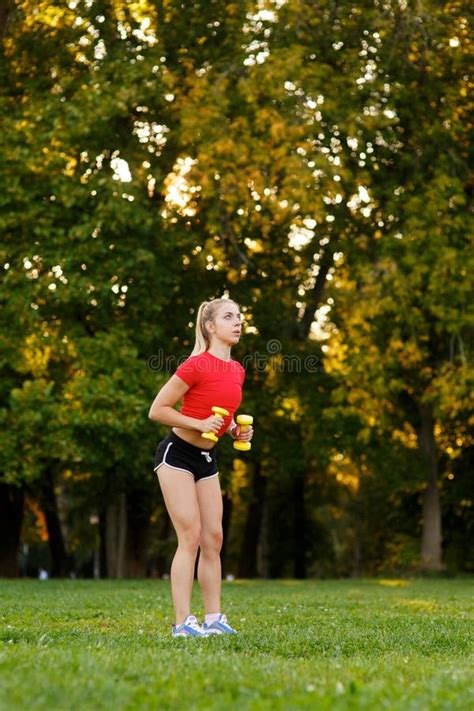 A Young Girl Goes In For Sports With Dumbbells In Nature Fitness Woman Workout Outdoors In The