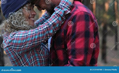 adult couple hug and kiss with love in the nature outdoor leisure activity at the park romance