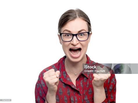A Portrait Of Young Brunette Woman Screaming Loudly She Looking At Camera And Her Hands Clenched