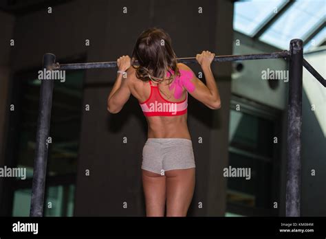 Mädchen In Sportkleidung Pull Ups Übungen An Der Bar In Der Turnhalle Aus Zurück