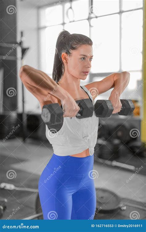 Sporty Woman Doing Exercises With Dumbbells Photo Of Muscular Female Wearing Sportswear In Gym