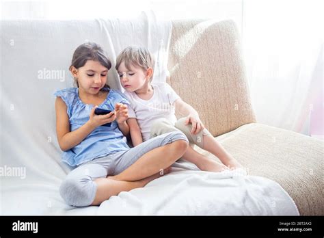 Kinder Zu Hause Sitzen Auf Dem Sofa Spielen Mit Tablet Nette Geschwister Bruder Und Schwester