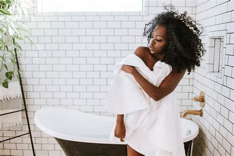 Woman Drying Off With Towel In Bathroom By Stocksy Contributor Leah Flores Stocksy