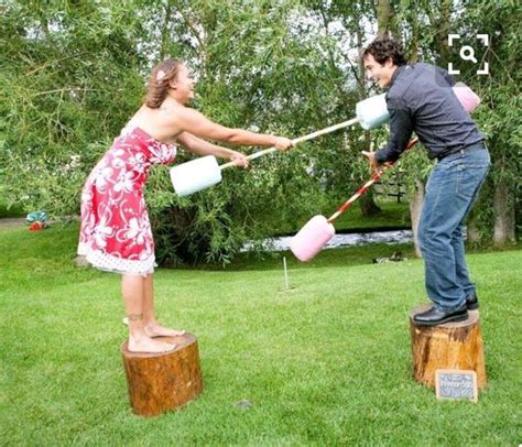 Two People Are Playing With Jugs In The Grass And One Person Is On A Stump