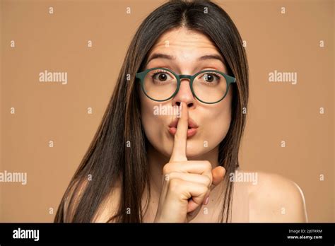 Portrait Of Young Woman Finger Covering Lips Mouth Do Not Tell Look Camera Isolated On Beige