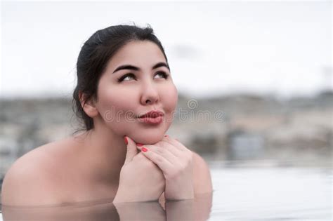 Plus Size Model In Black Bathing Suit Lying In Geothermal Mineral Water In Pool At Balneotherapy