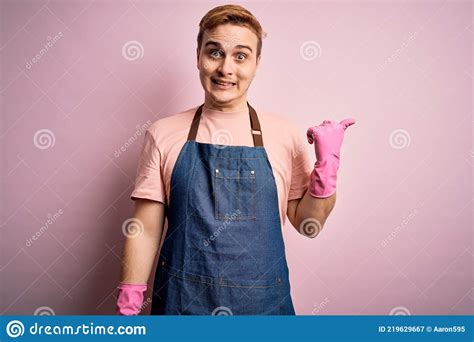 Young Handsome Redhead Cleaner Man Doing Housework Wearing Apron And Gloves Smiling With Happy