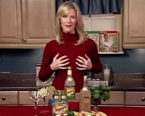 A Woman Standing In Front Of A Table Full Of Food And Wine Bottles On It