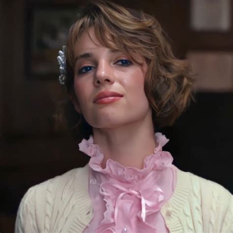 A Woman With Short Hair Wearing A Pink Blouse