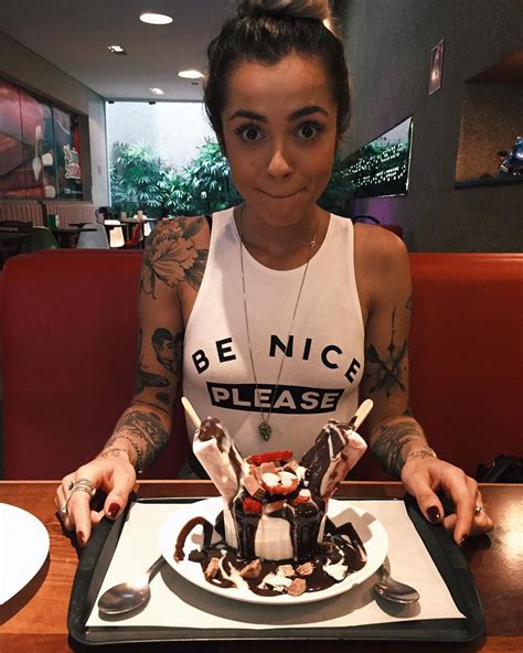 A Woman Sitting At A Table In Front Of A Plate With Desserts On It