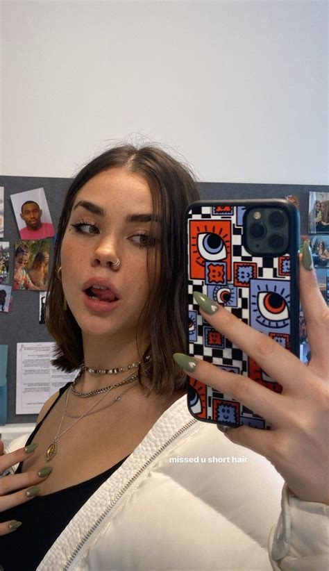 A Woman Holding Up Her Cell Phone To Take A Selfie In Front Of The Camera