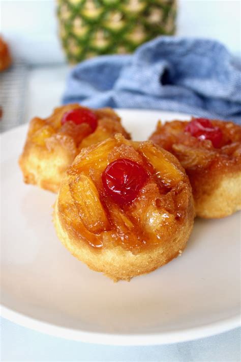 Three Pineapple Upside Down Pastries On A White Plate Next To A Pineapple