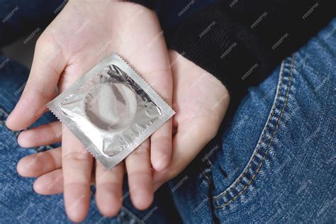 Premium Photo Condom Ready To Use In Female Hand Give Condom Safe Sex Concept On The Bed