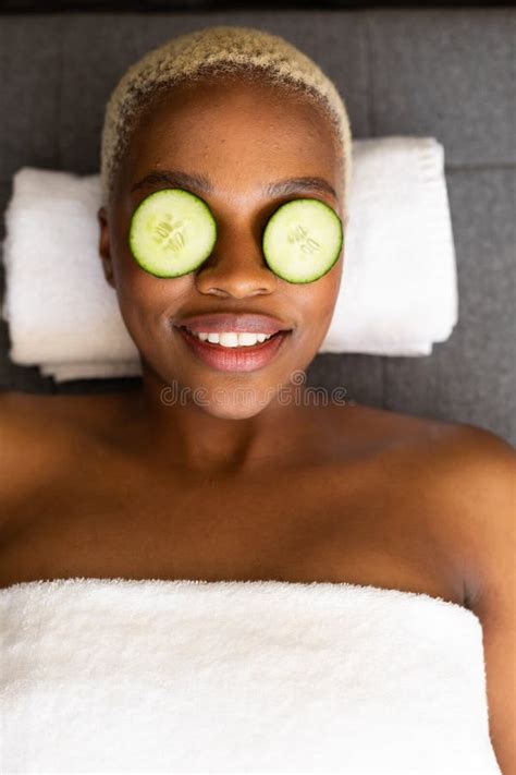 Happy African American Woman Lying On Towel With Cucumber Slices On Her Eyes Stock Image Image