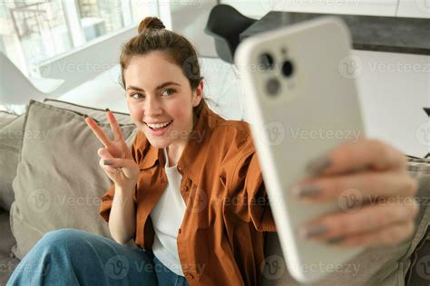 Portrait Of Beautiful Happy Girl Takes Selfies On Sofa Woman Posing For Photos On Her Couch