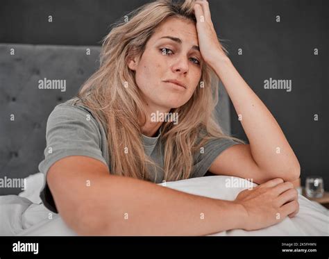 Depression Tired And Portrait Of A Sick Woman Sitting On The Bed In Her Bedroom At Home