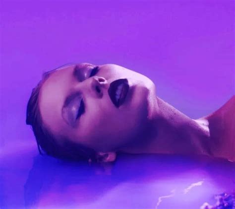 A Woman Laying On The Ground With Her Eyes Closed And One Eye Half Open In Front Of Her Face