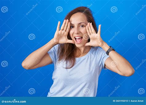 Brunette Woman Standing Over Blue Background Smiling Cheerful Playing Peek A Boo With Hands