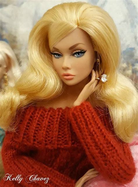 A Barbie Doll With Blonde Hair And Blue Eyes Wearing A Red Knitted Sweater Is Posed For The Camera