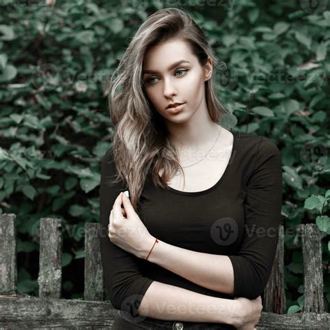 Portrait Of A Beautiful Country Girl In A Black T Shirt Near The Green Foliage 23334917 Stock