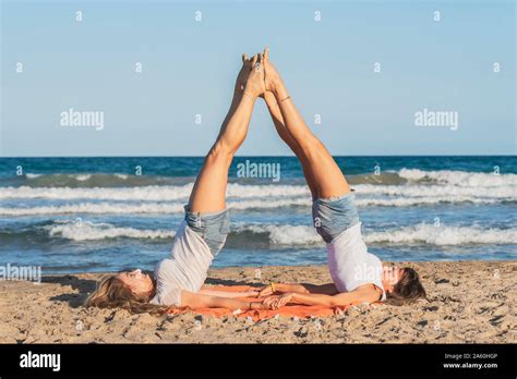 Two Women Praticing Acro Yoga On The Beach Stock Photo Alamy
