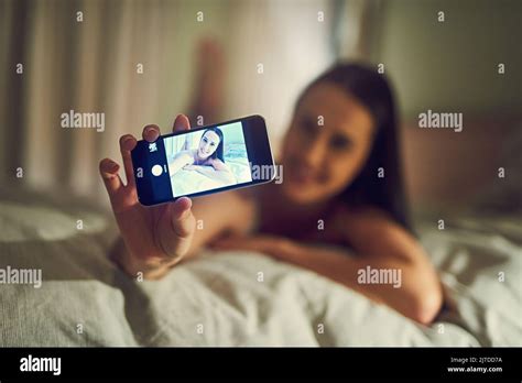 Best Selfie Ever A Young Woman Showing A Cellphone Selfie While Lying On Her Bed In Her Bedroom