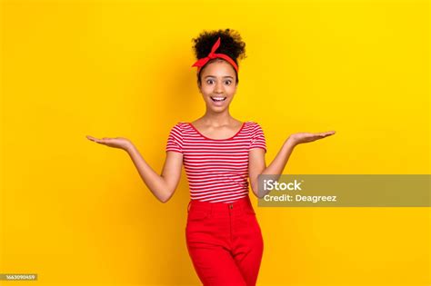 Photo Of Sweet Impressed Girl Dressed Red Striped Tshirt Comparing Arms Empty Space Isolated