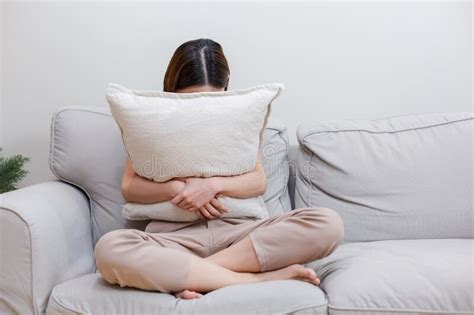 Female Having Depression Sitting Alone On Sofa She With Depressed Embracing Pillow Unhappy