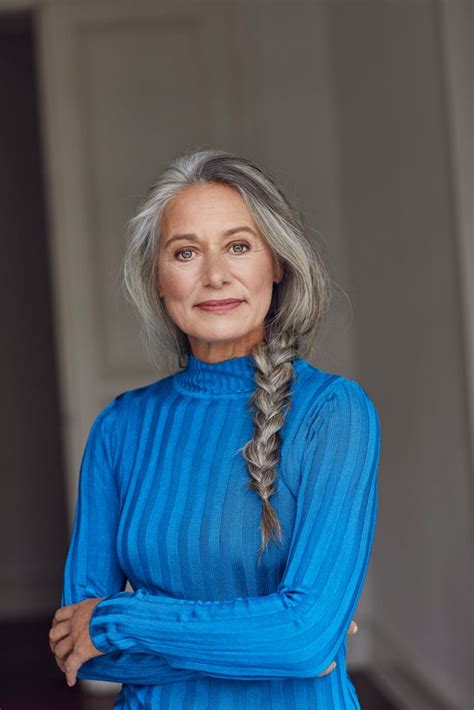 An Older Woman With Grey Hair Wearing A Blue Top