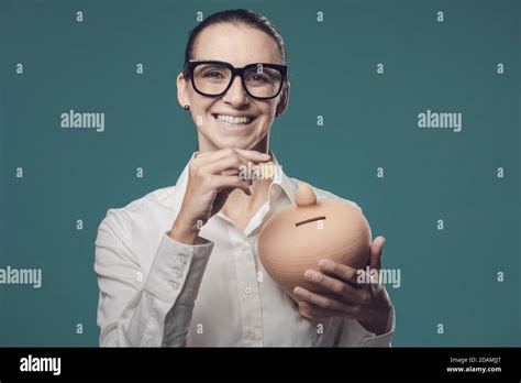 Happy Business Woman Putting Her Savings In A Safe Money Box Investments And Finance Concept